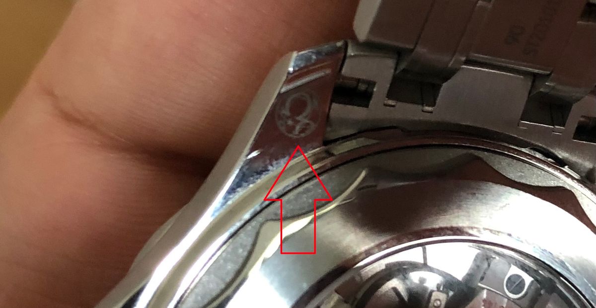 Is this logo at the back of the watch etched or a sticker on top of it ...